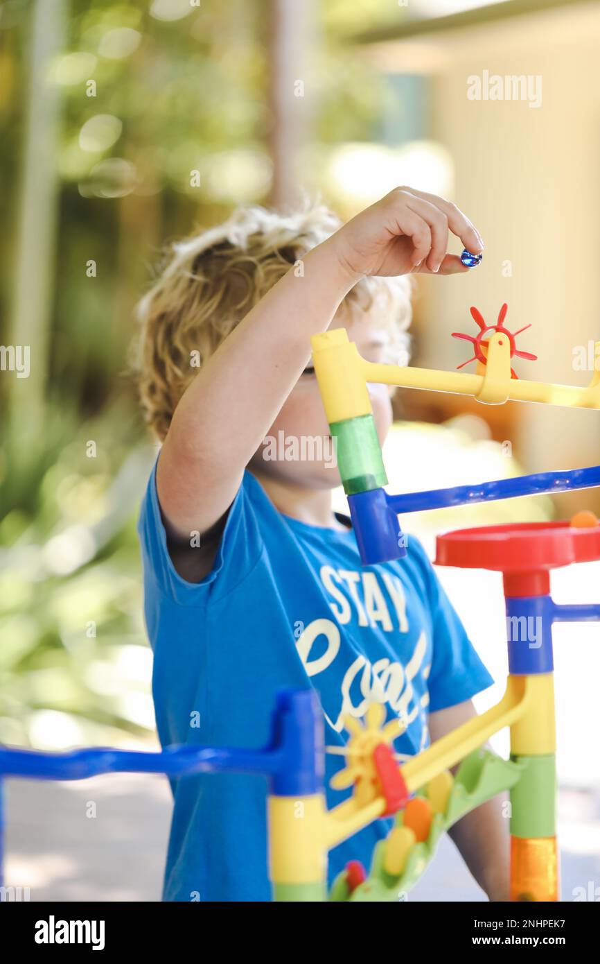 Child playing with colorful marble tower in preschool garden Stock ...