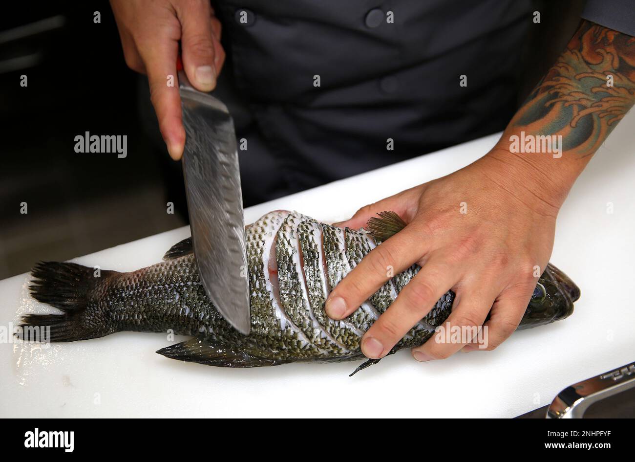 Black bass is sliced in making Pla Sam Ros--a sweet and sour black sea ...