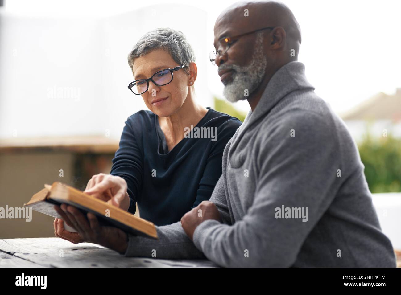They enjoy reading the bible together. an affectionate senior couple ...