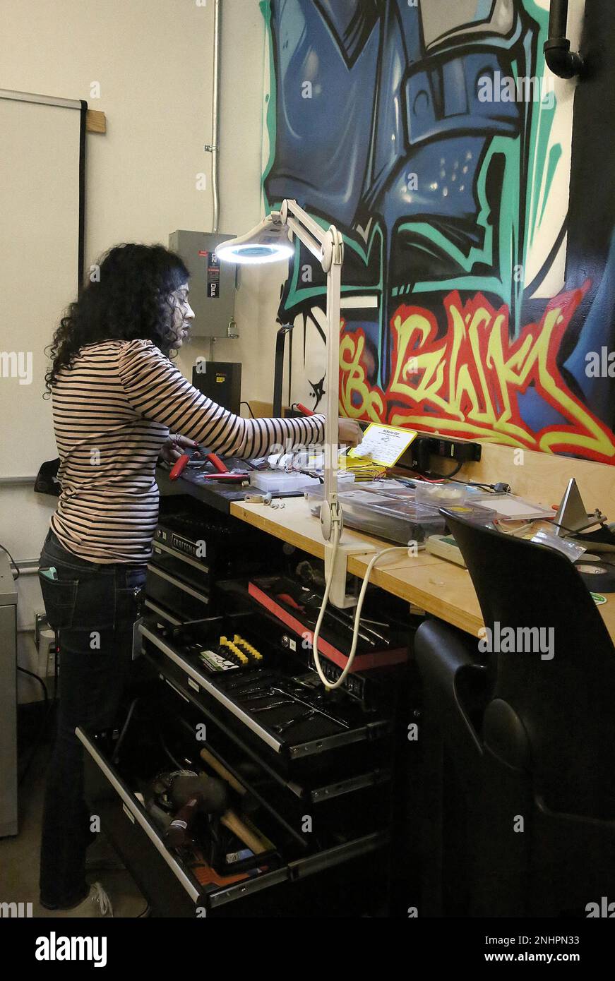 Mechanical engineer Divya Kulkarni wiring harness in the garage of ...