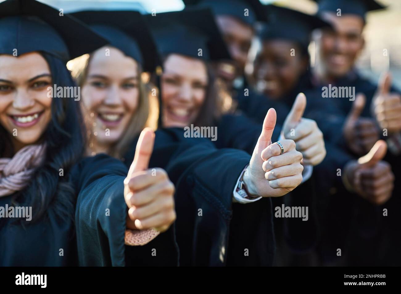 Happy graduation students thumbs up hi-res stock photography and images ...