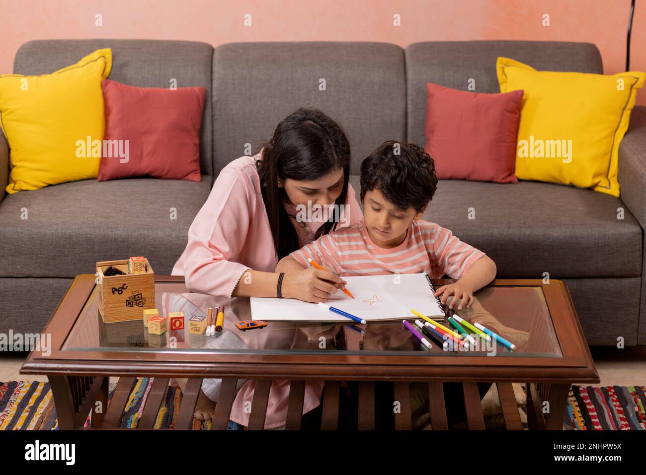 Mother helping her son with drawing Stock Photo - Alamy