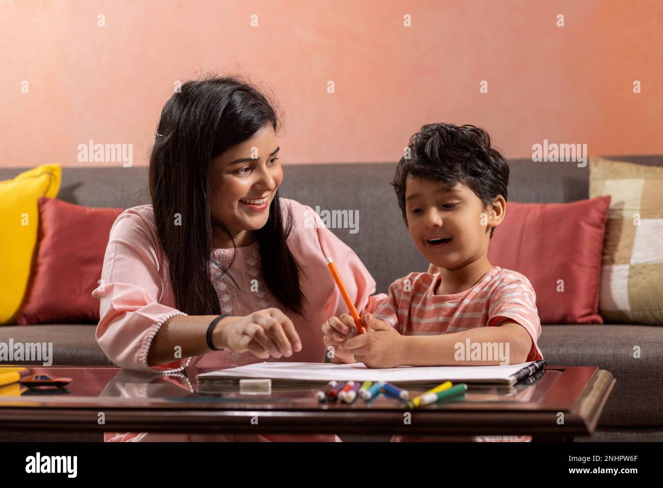 Mother helping her son with drawing Stock Photo - Alamy