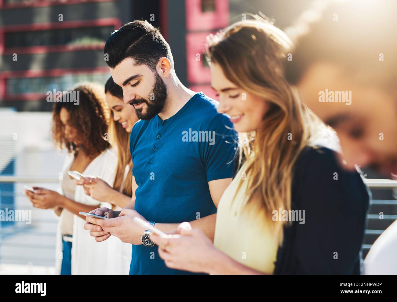 Smiling man sending message to friends hi-res stock photography and ...