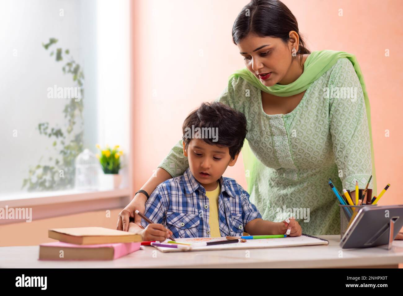 Mother helping her son with drawing Stock Photo - Alamy