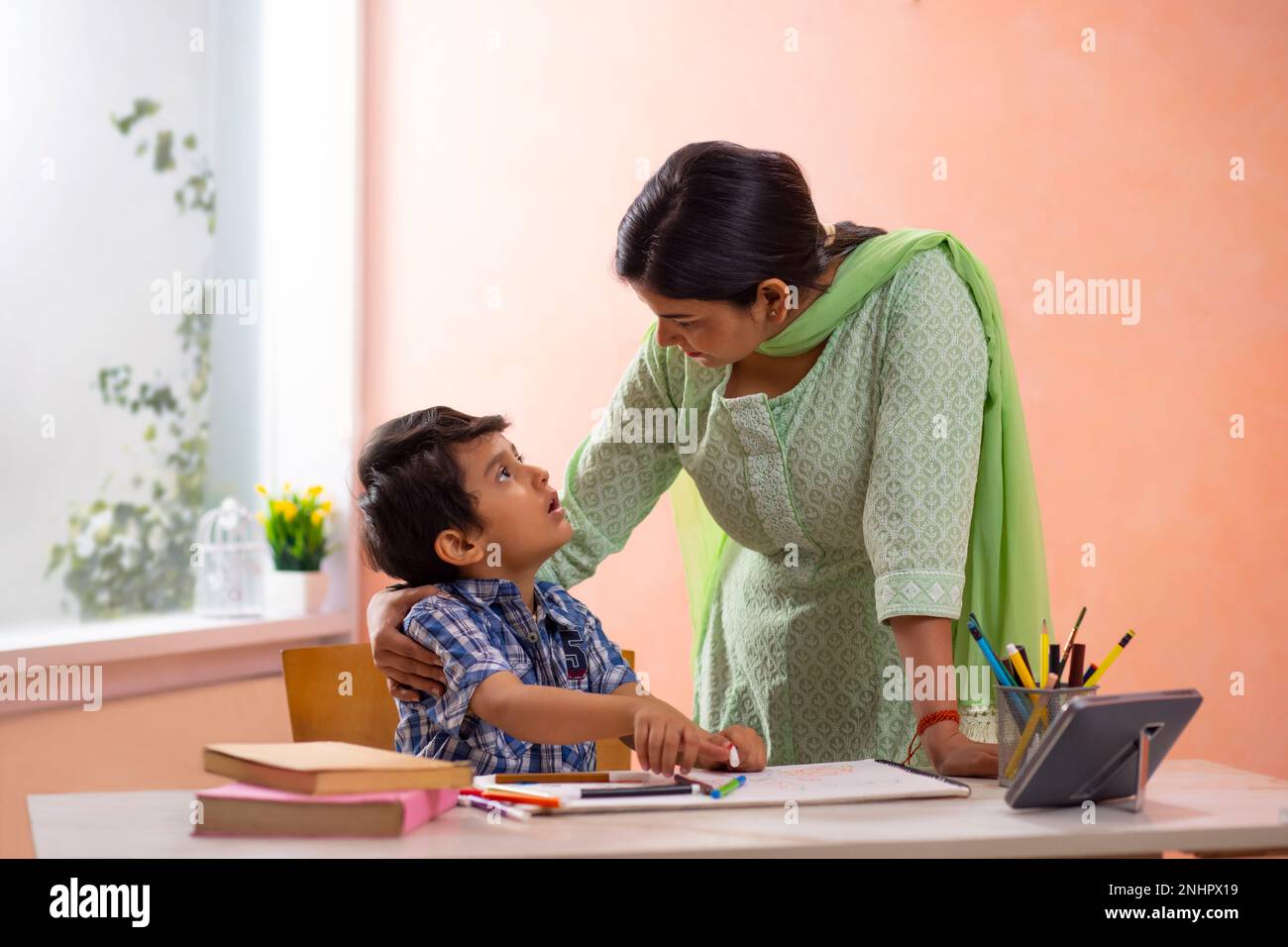 Mother helping her son with drawing Stock Photo - Alamy