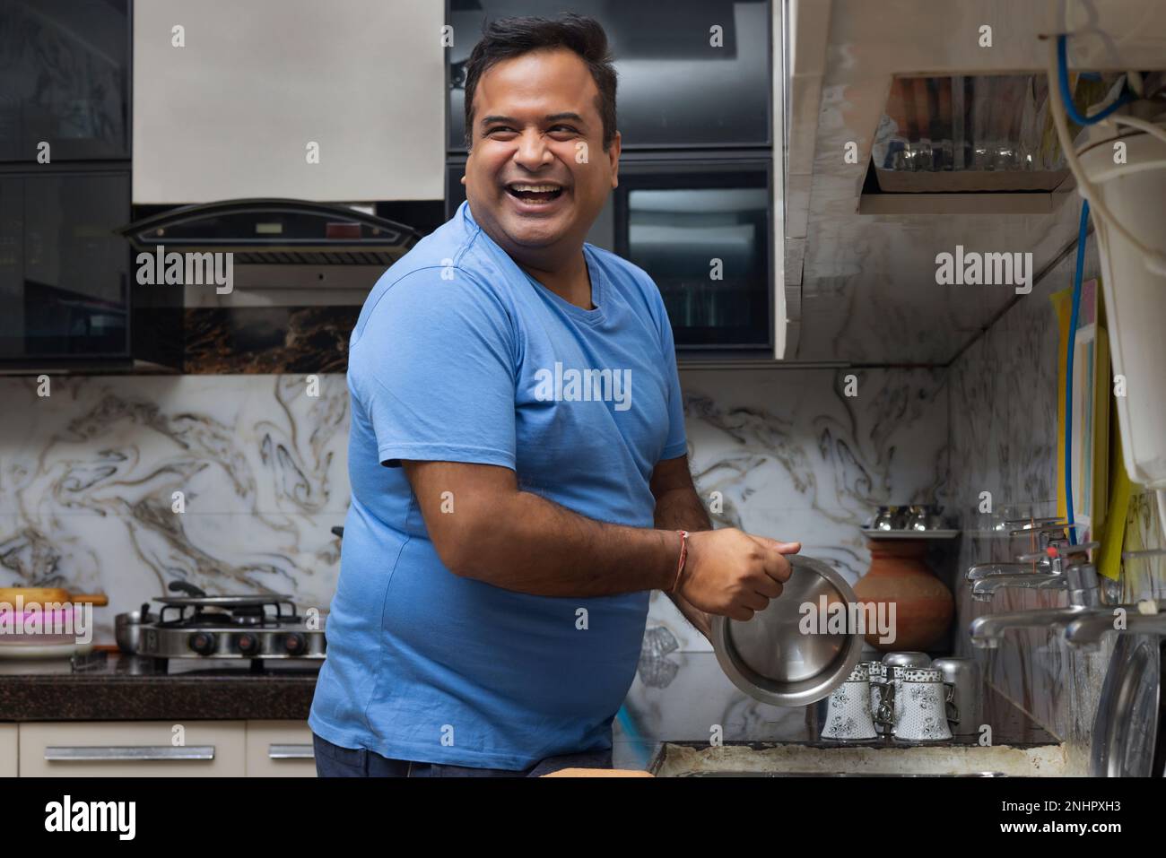 Portrait of man washing utensil in kitchen at home Stock Photo - Alamy