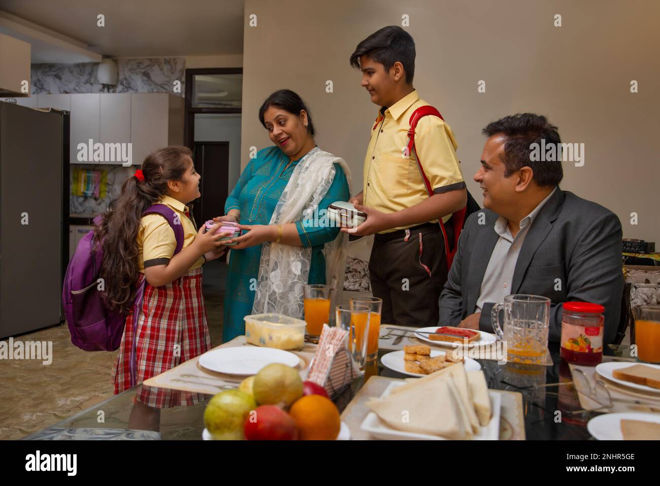 Mother giving lunch box to her daughter before school Stock Photo - Alamy