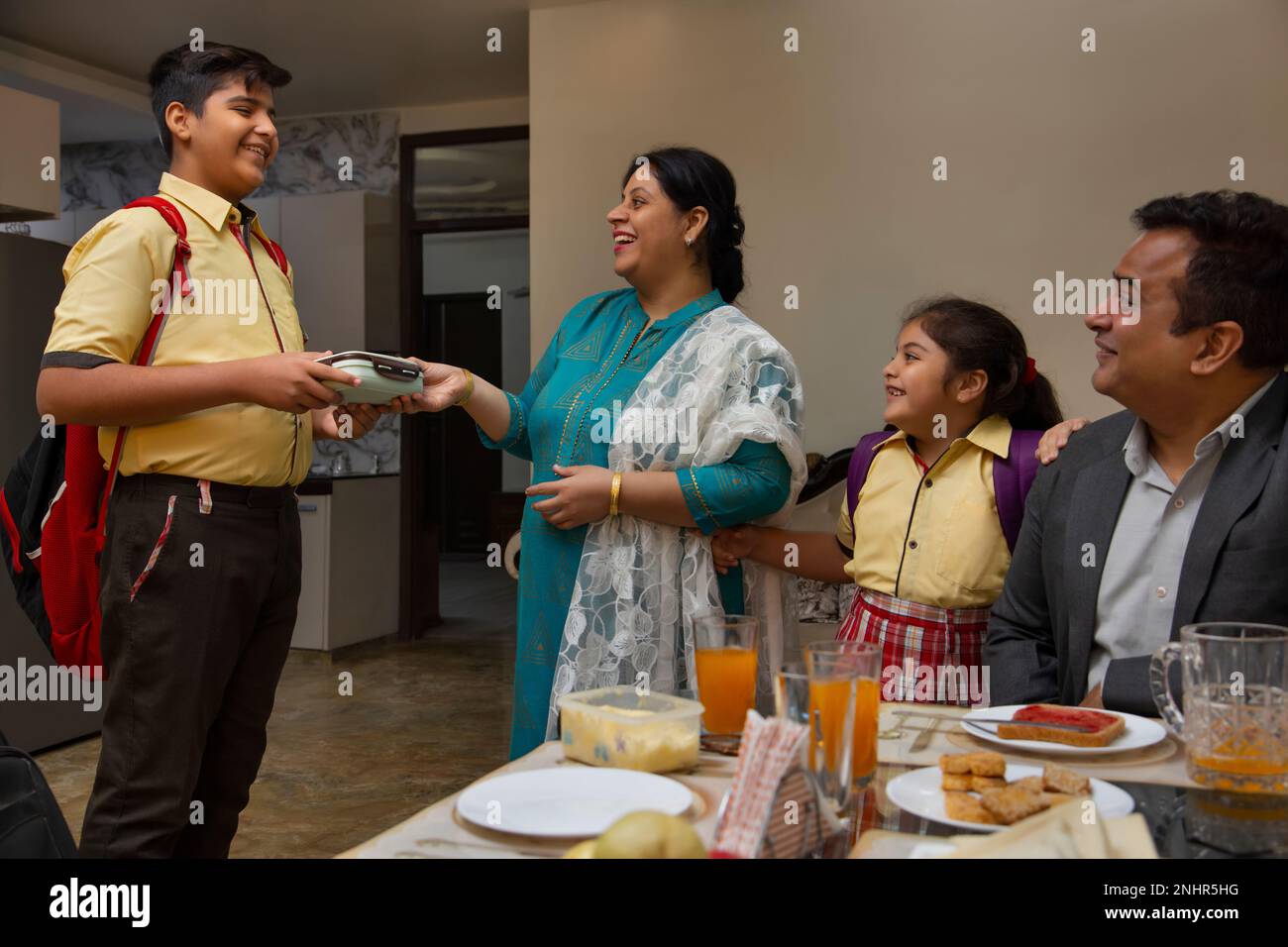 Mother giving lunch box to her son before school Stock Photo - Alamy