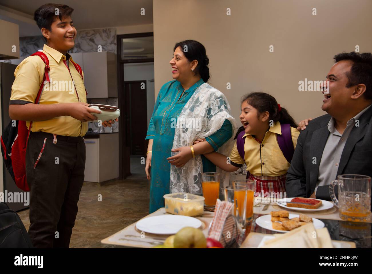 Mother giving lunch box to her son before school Stock Photo - Alamy