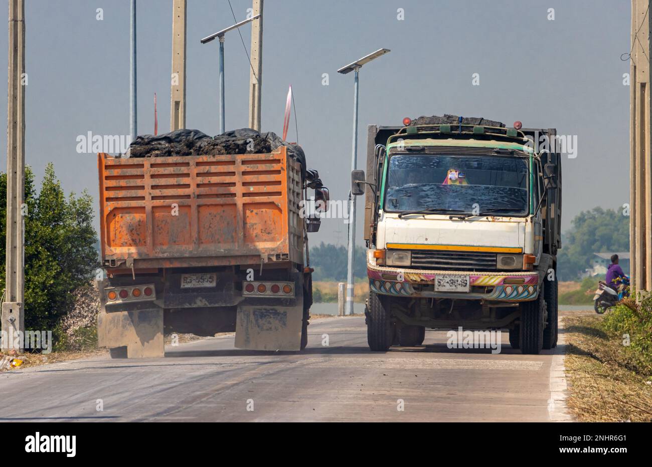 Two trucks pass close by on a country road Stock Photo - Alamy