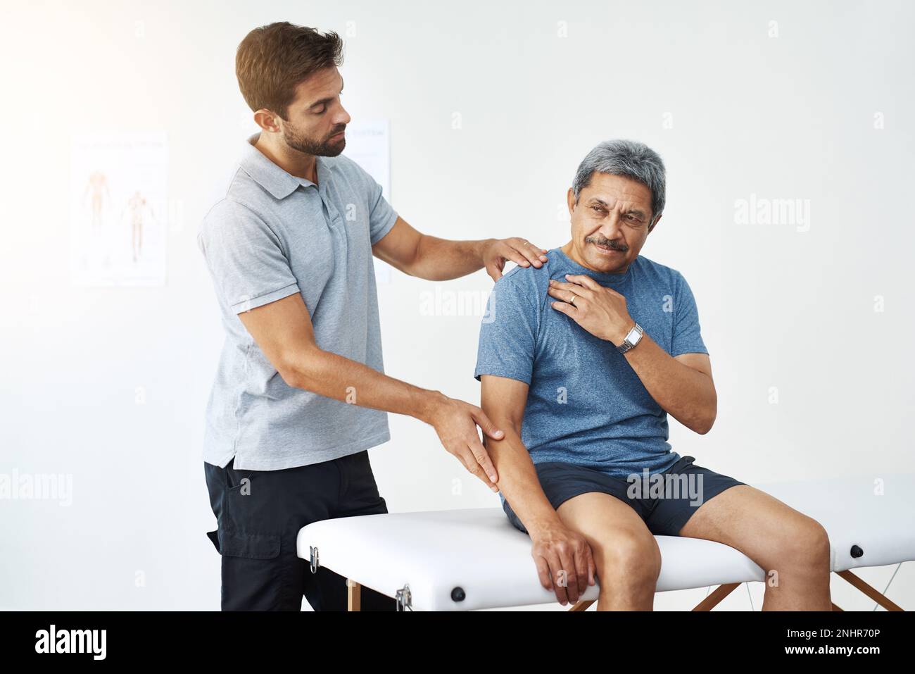 You did well today. a young male physiotherapist helping a mature male ...