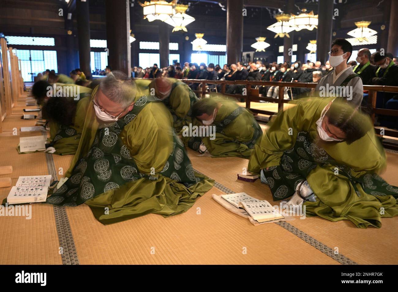 Monks moving their bodies in all directions chant a Buddhist sutra ...