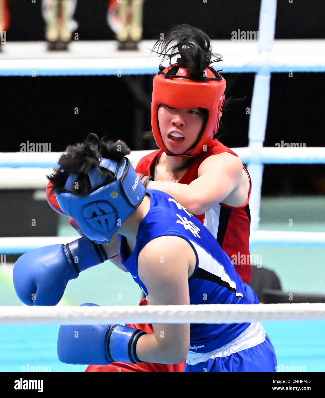 Japanese boxer Sena Irie (red) delivers a punch during the women's featherweight final match of ...
