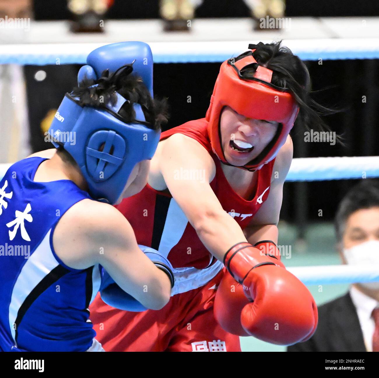 Japanese boxer Sena Irie (red) delivers a punch during the women's featherweight final match of ...