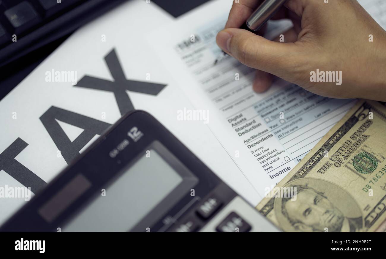 Tax season concept. Woman hand filling US individual income tax return ...