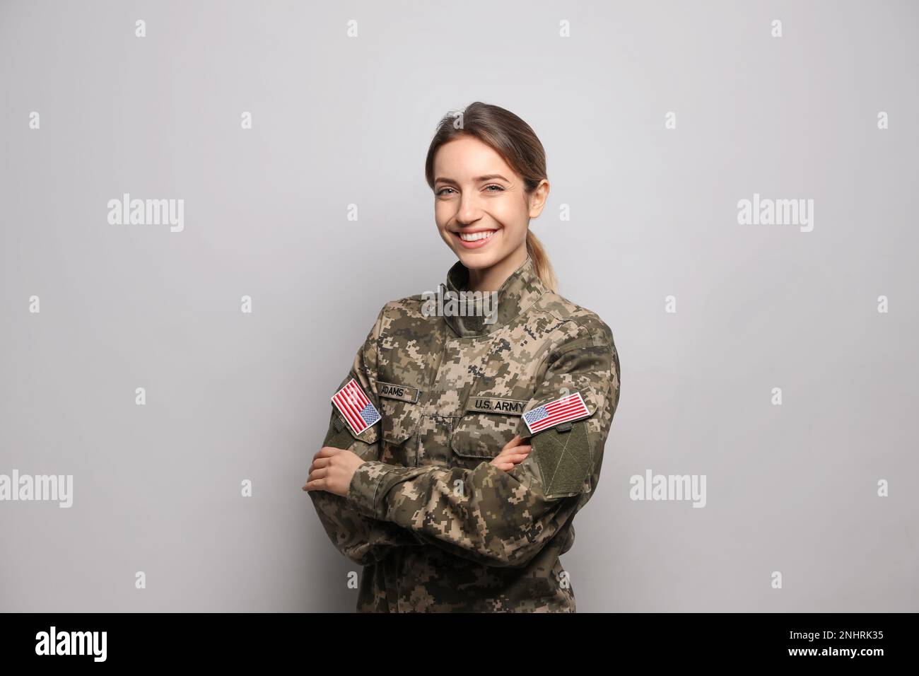 Portrait of happy female cadet on light grey background Stock Photo - Alamy
