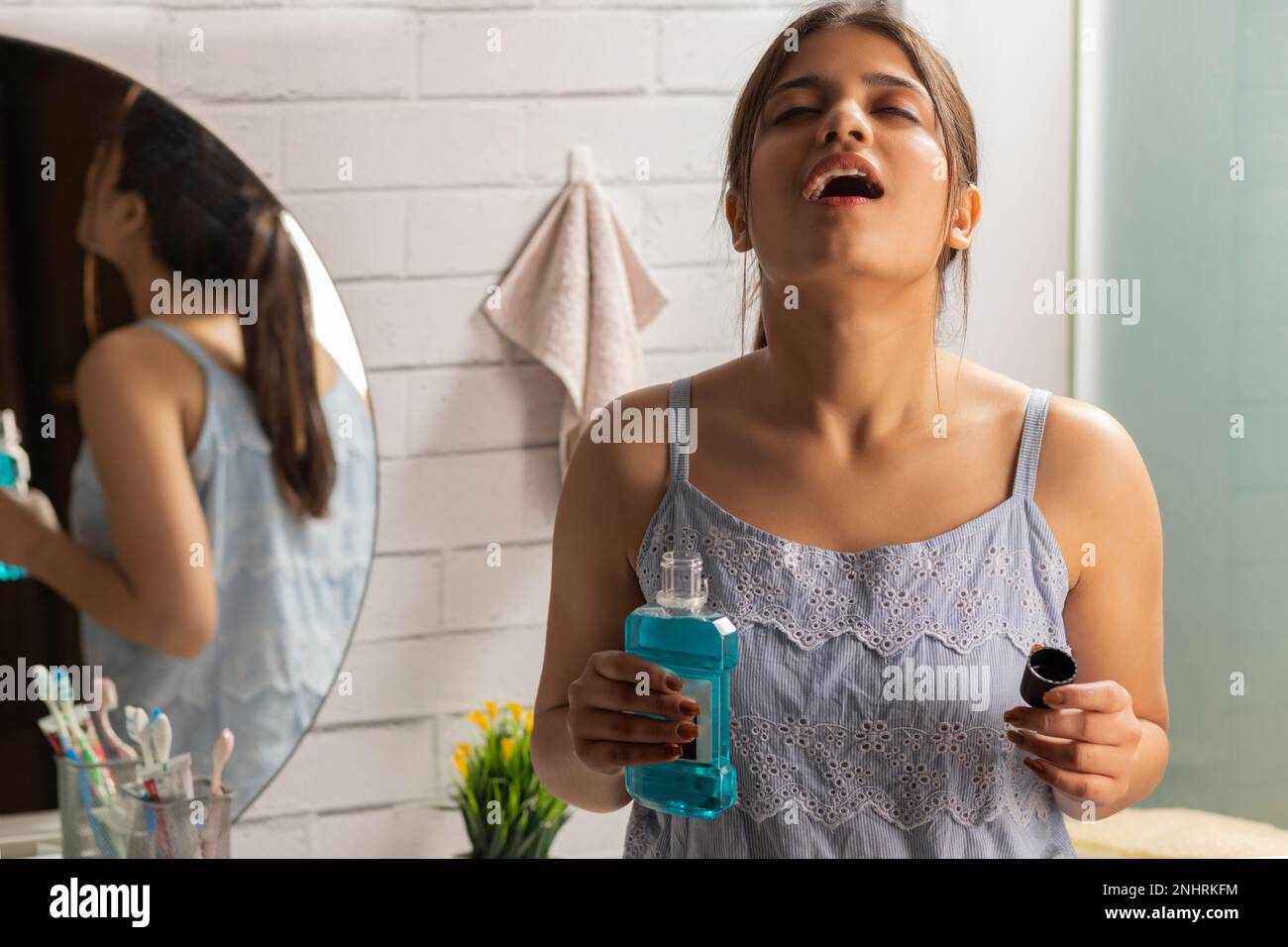 Woman gargling with mouthwash in bathroom Stock Photo - Alamy
