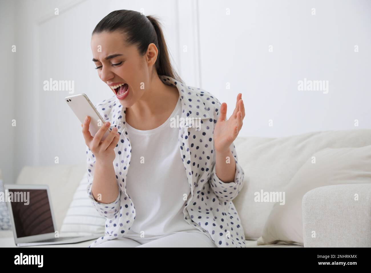 Emotional young woman talking on smartphone at home. Hate concept Stock ...