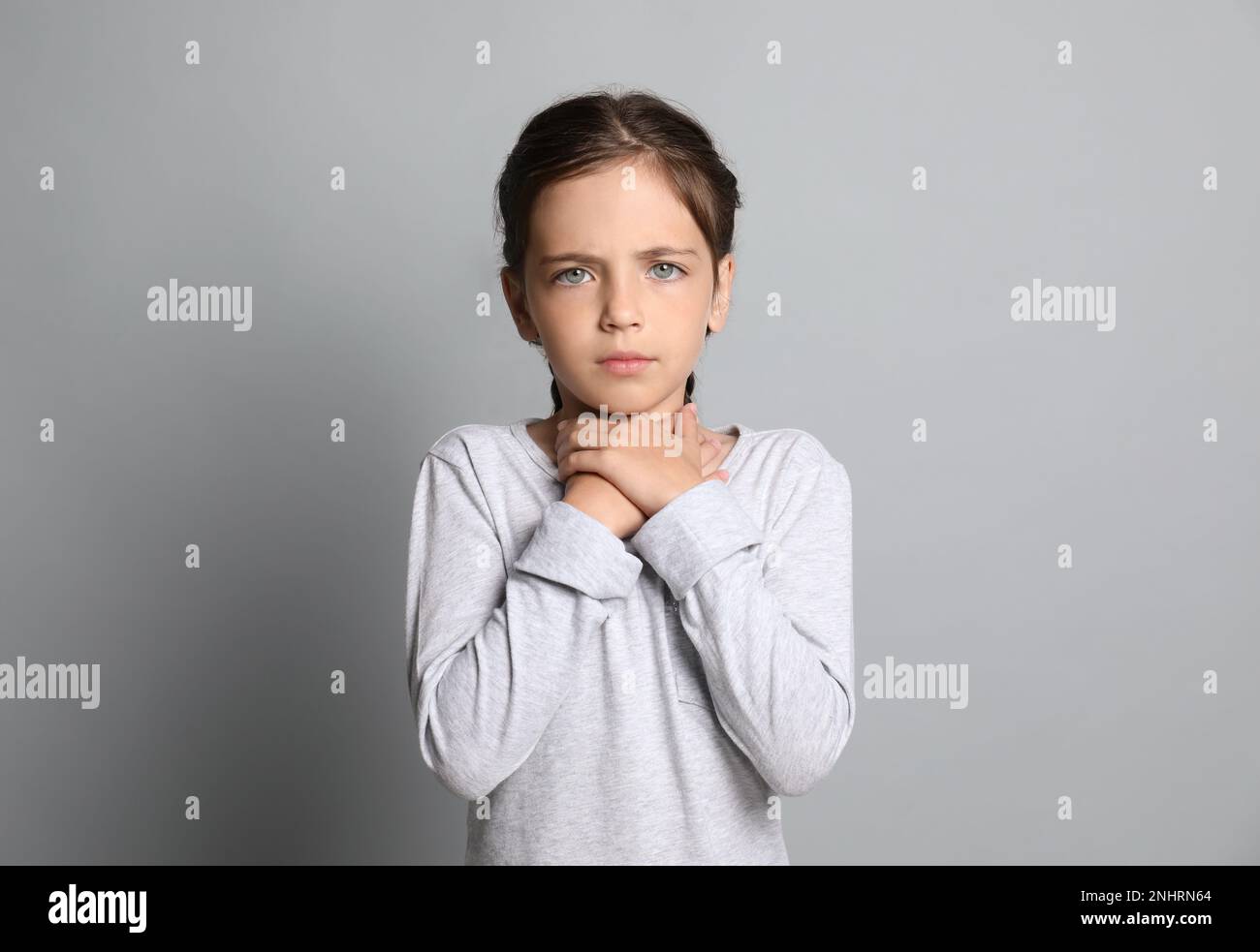 Little girl suffering from sore throat on grey background Stock Photo ...