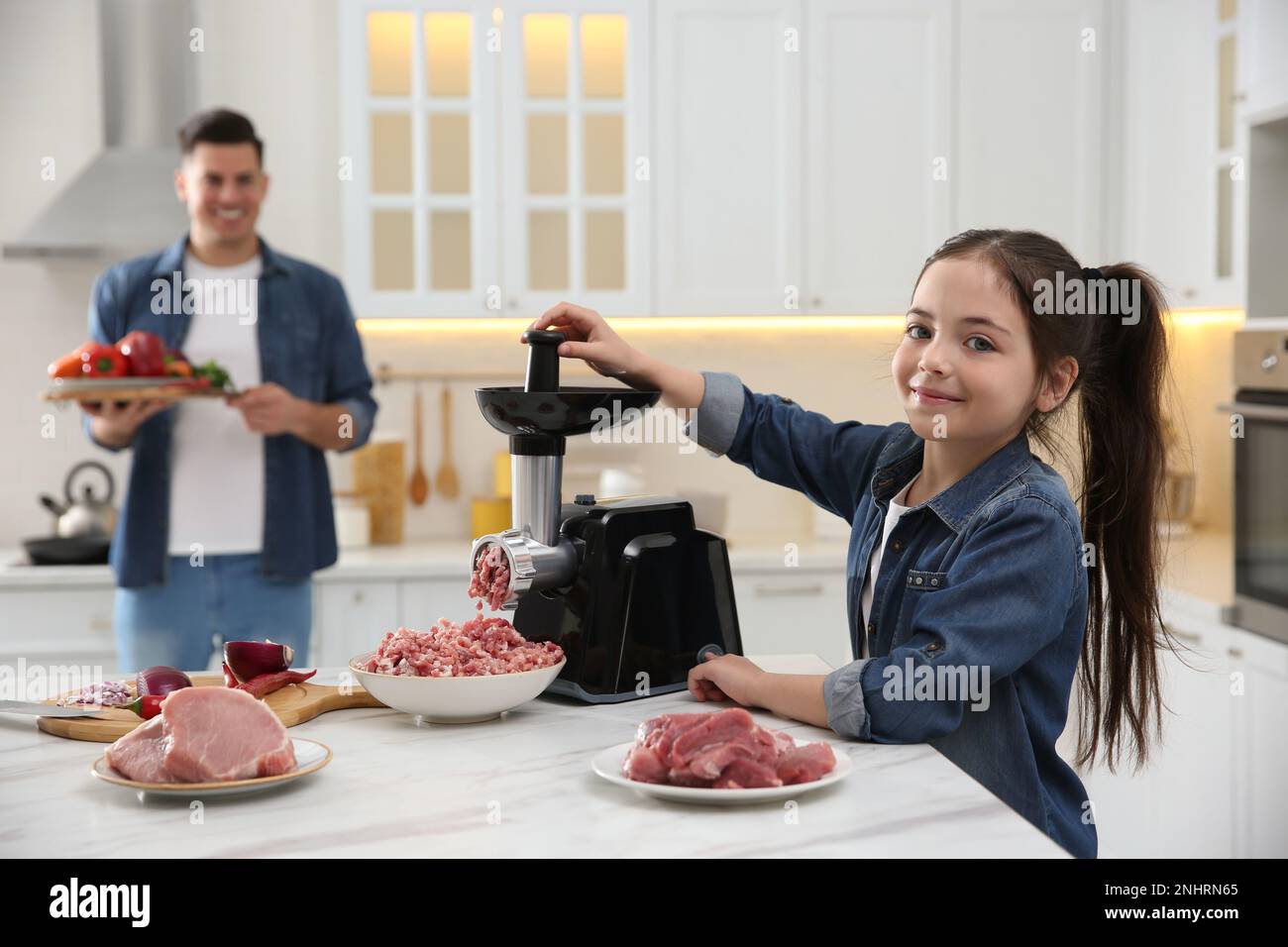 Little girl using modern meat grinder in kitchen Stock Photo - Alamy