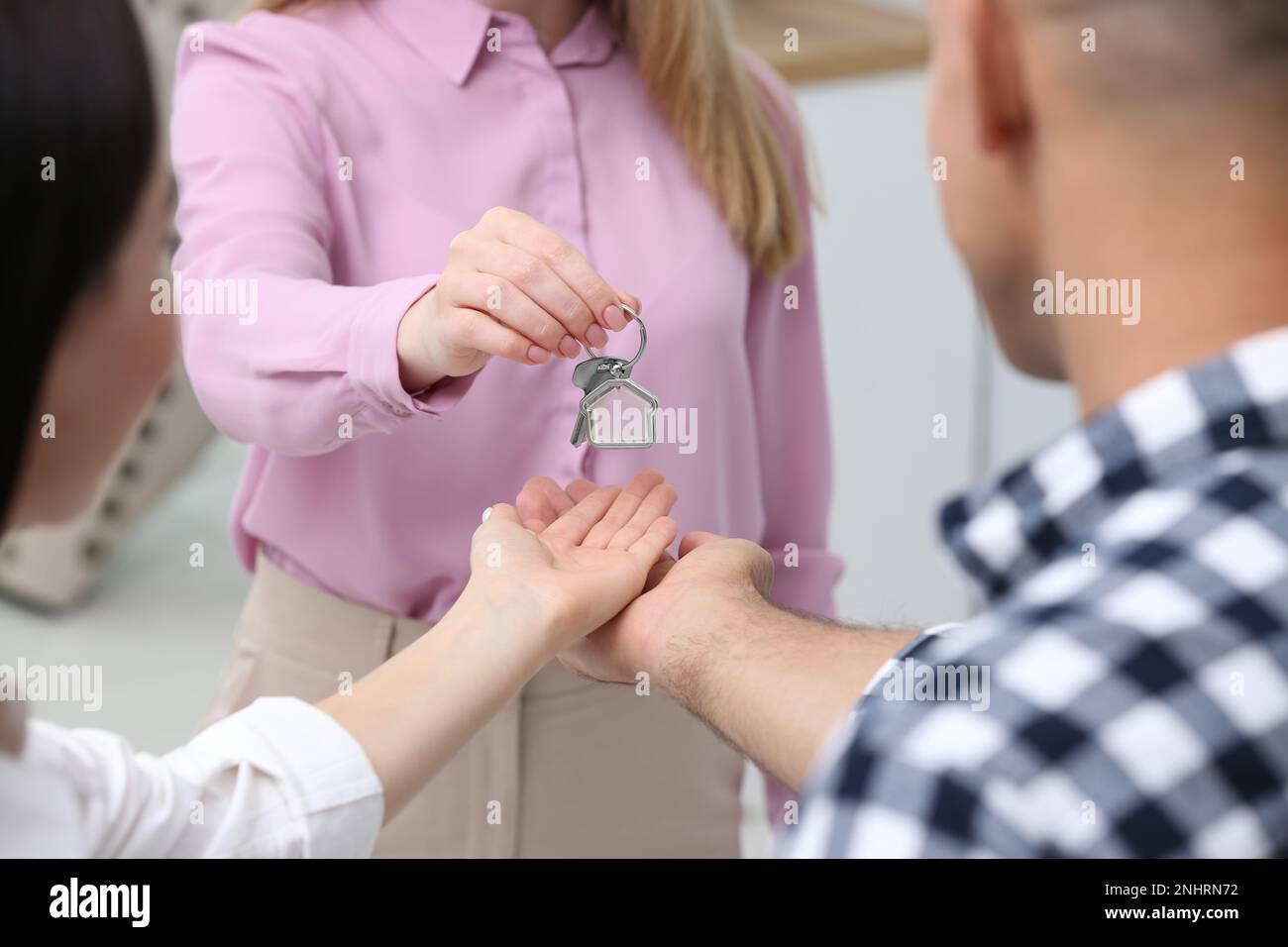 Real estate agent giving house key to couple, closeup Stock Photo - Alamy