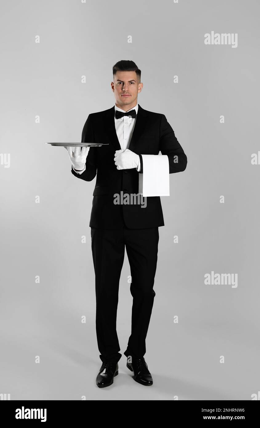 Handsome butler with tray on light grey background Stock Photo - Alamy
