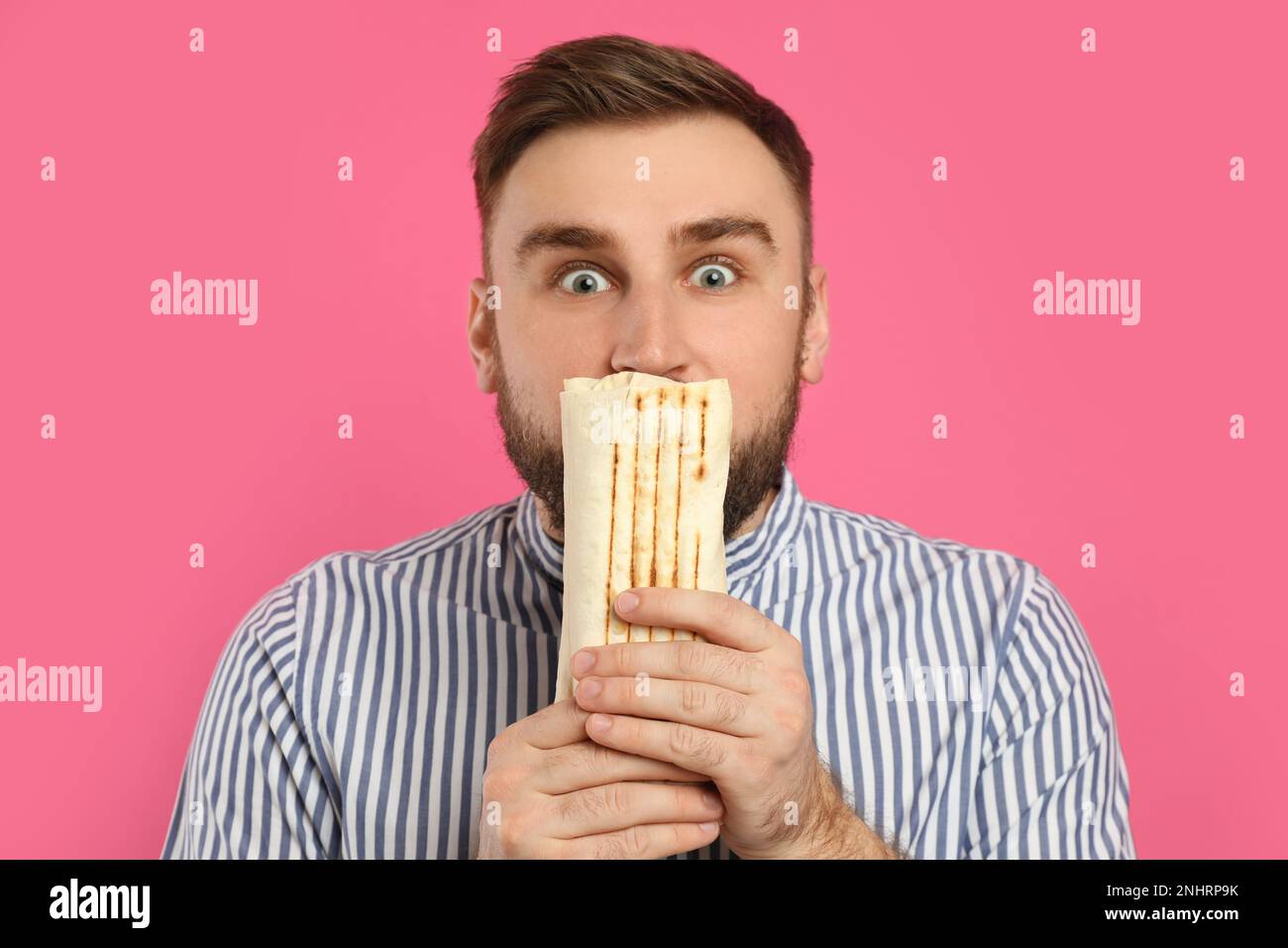 Emotional young man with delicious shawarma on pink background Stock ...