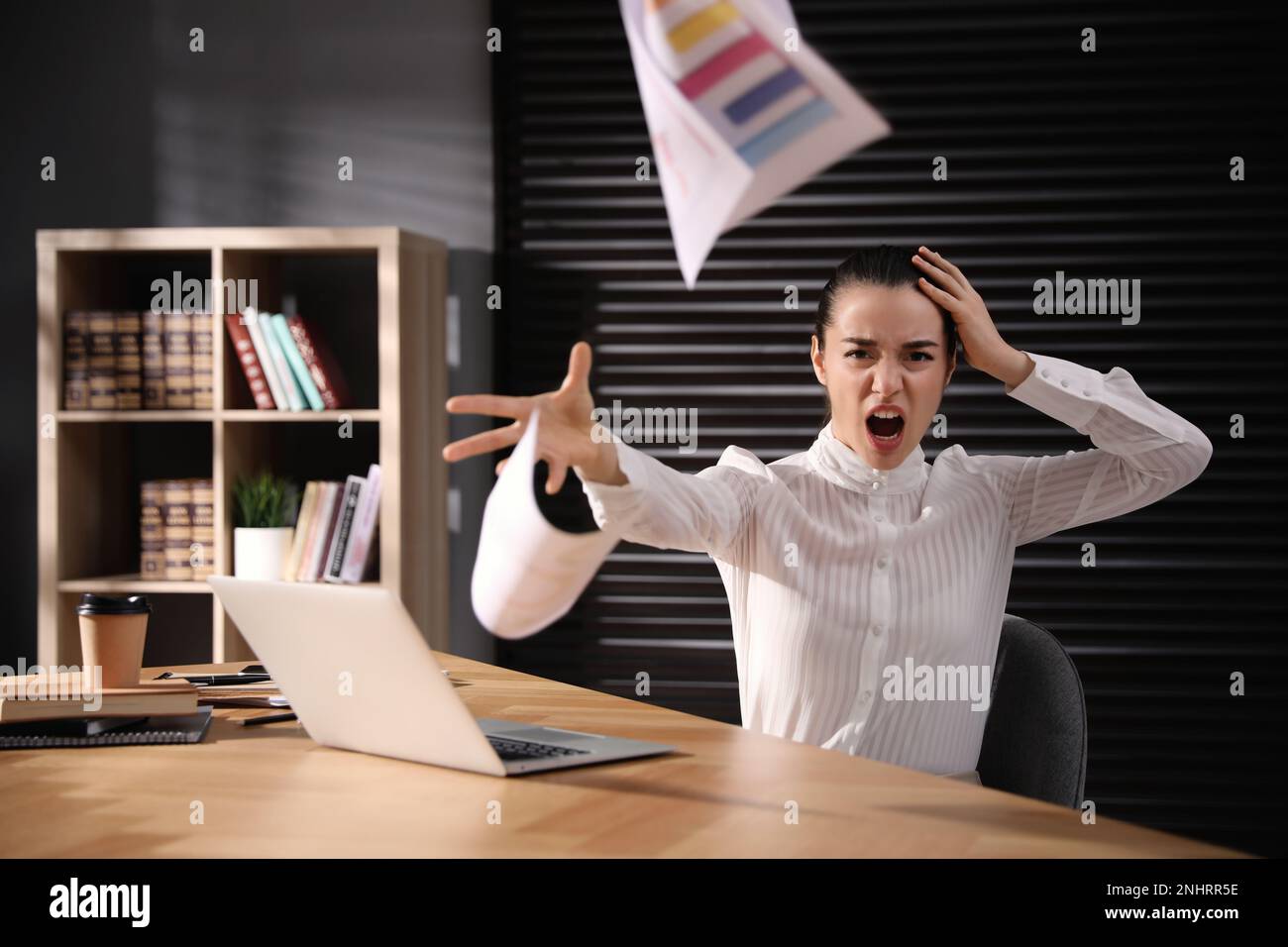 Emotional young businesswoman throwing papers at table in office. Hate ...