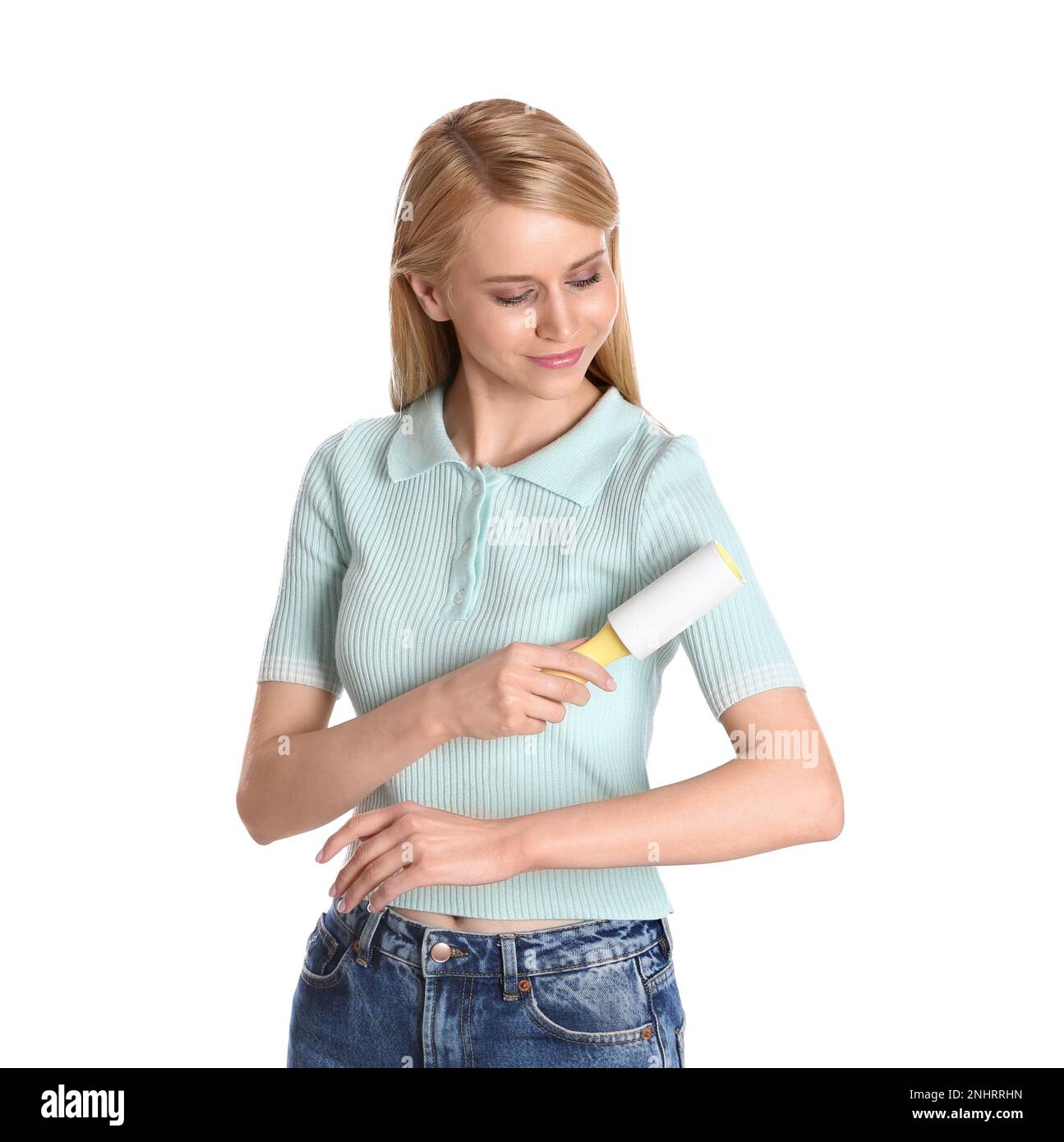 Young woman cleaning clothes with lint roller on white background Stock ...