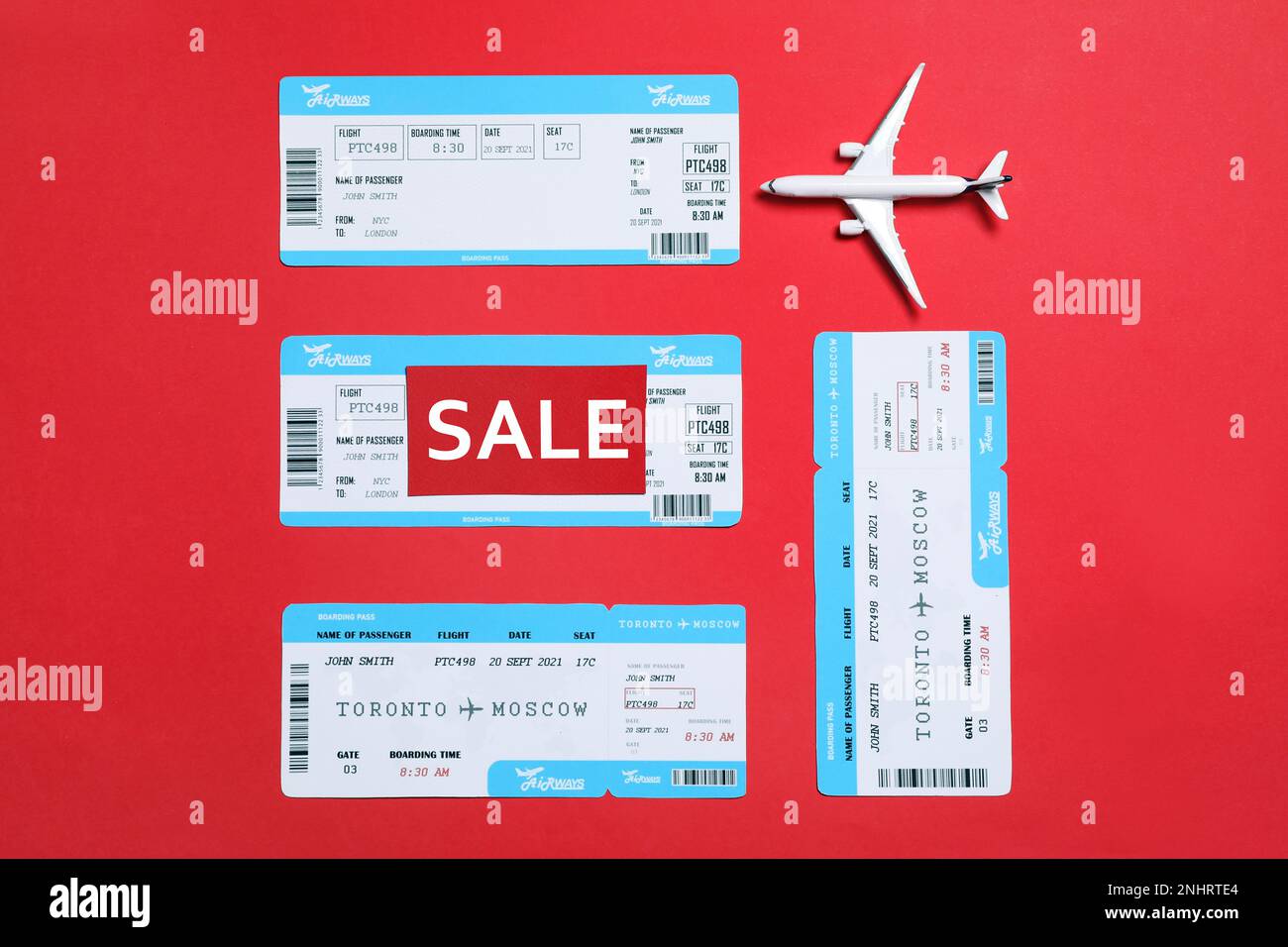 Flight tickets, plane model and SALE card on red background, flat lay ...