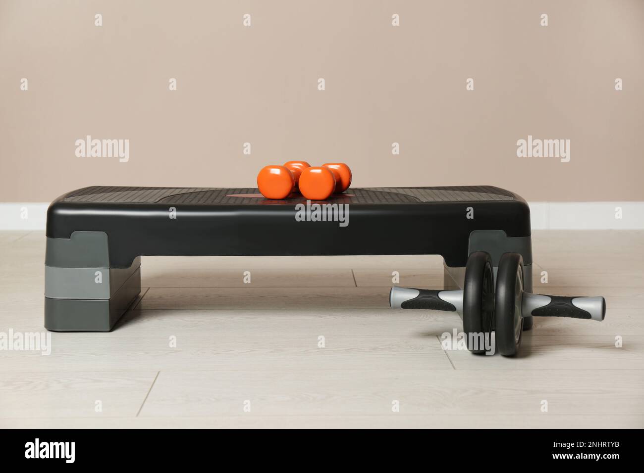Step platform, dumbbells and abdominal wheel indoors. Sports equipment ...
