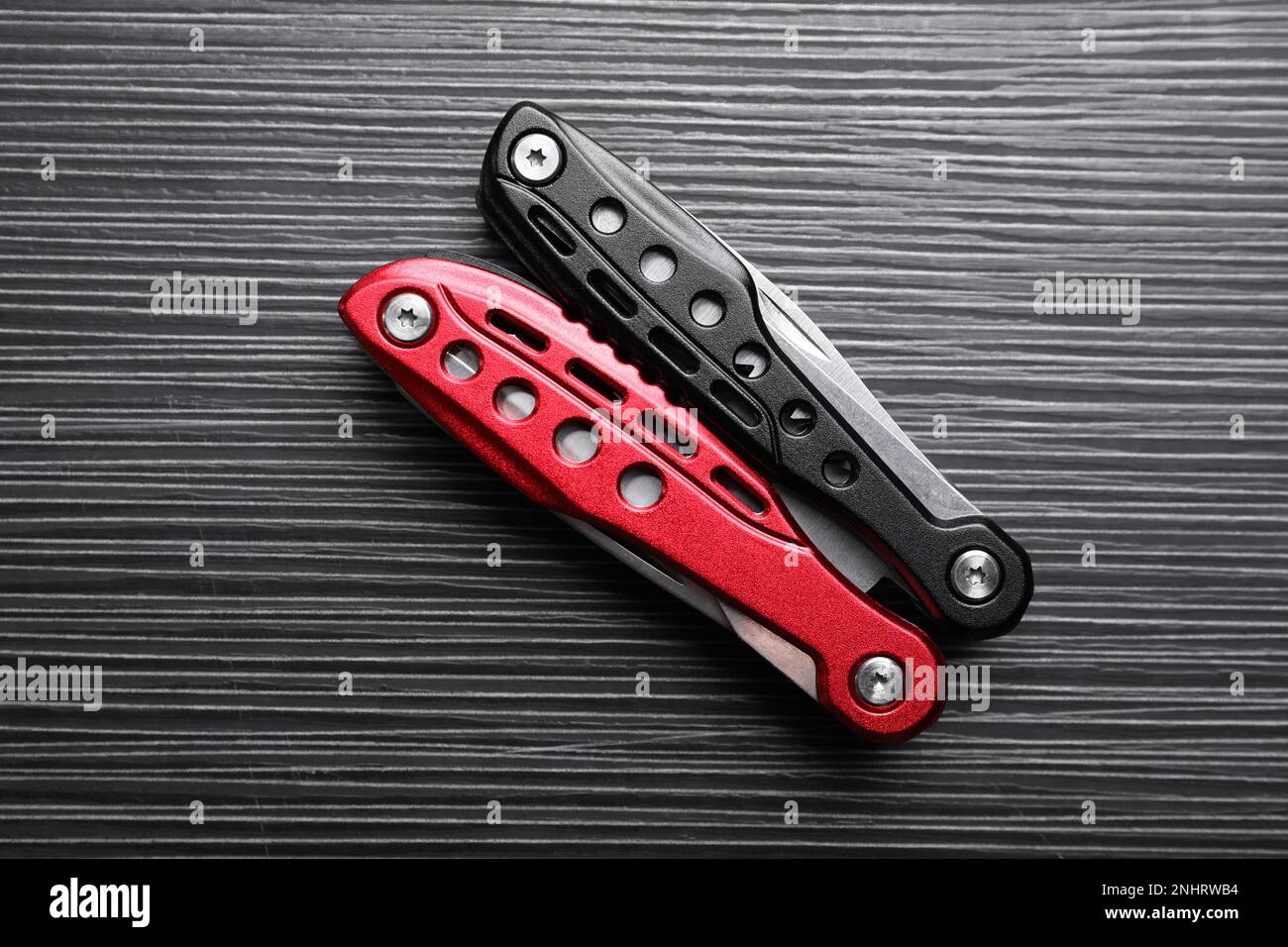 Modern compact portable multitool on black wooden table, top view Stock ...