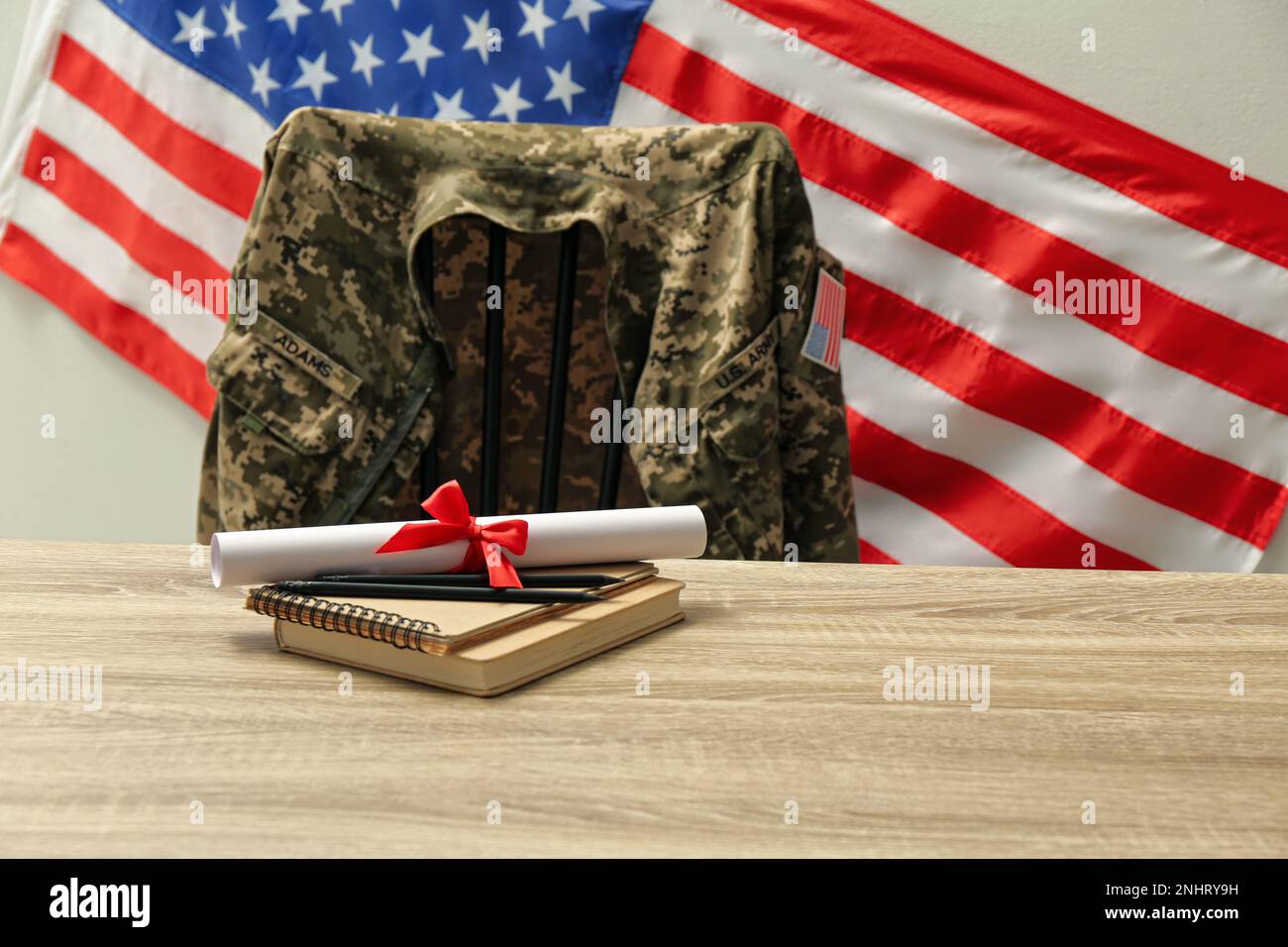 Diploma, notebooks and soldier uniform near flag of United States ...