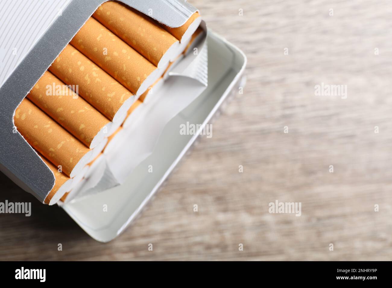 Cigarettes in pack on wooden table, top view. Space for text Stock ...