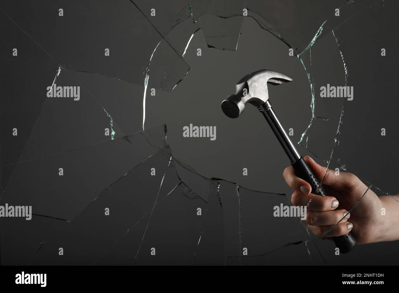 Woman breaking window with hammer on grey background, closeup Stock ...