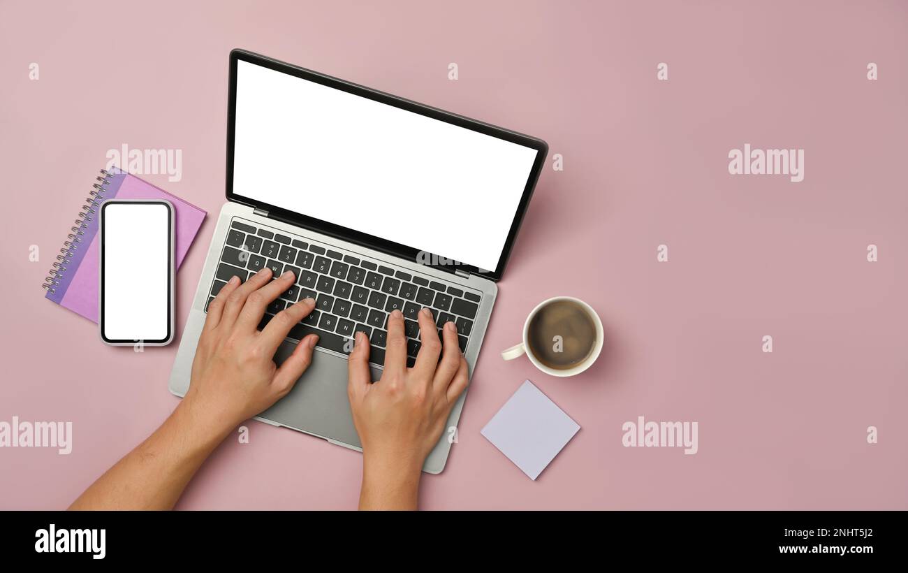 Overhead view of woman hands typing on laptop computer with smart phone ...