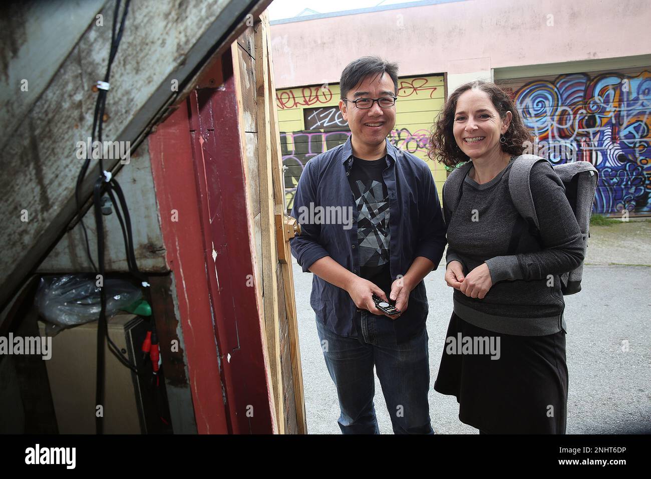 Curator Sarah Klein (right) and David Kwan (middle) work on changing ...