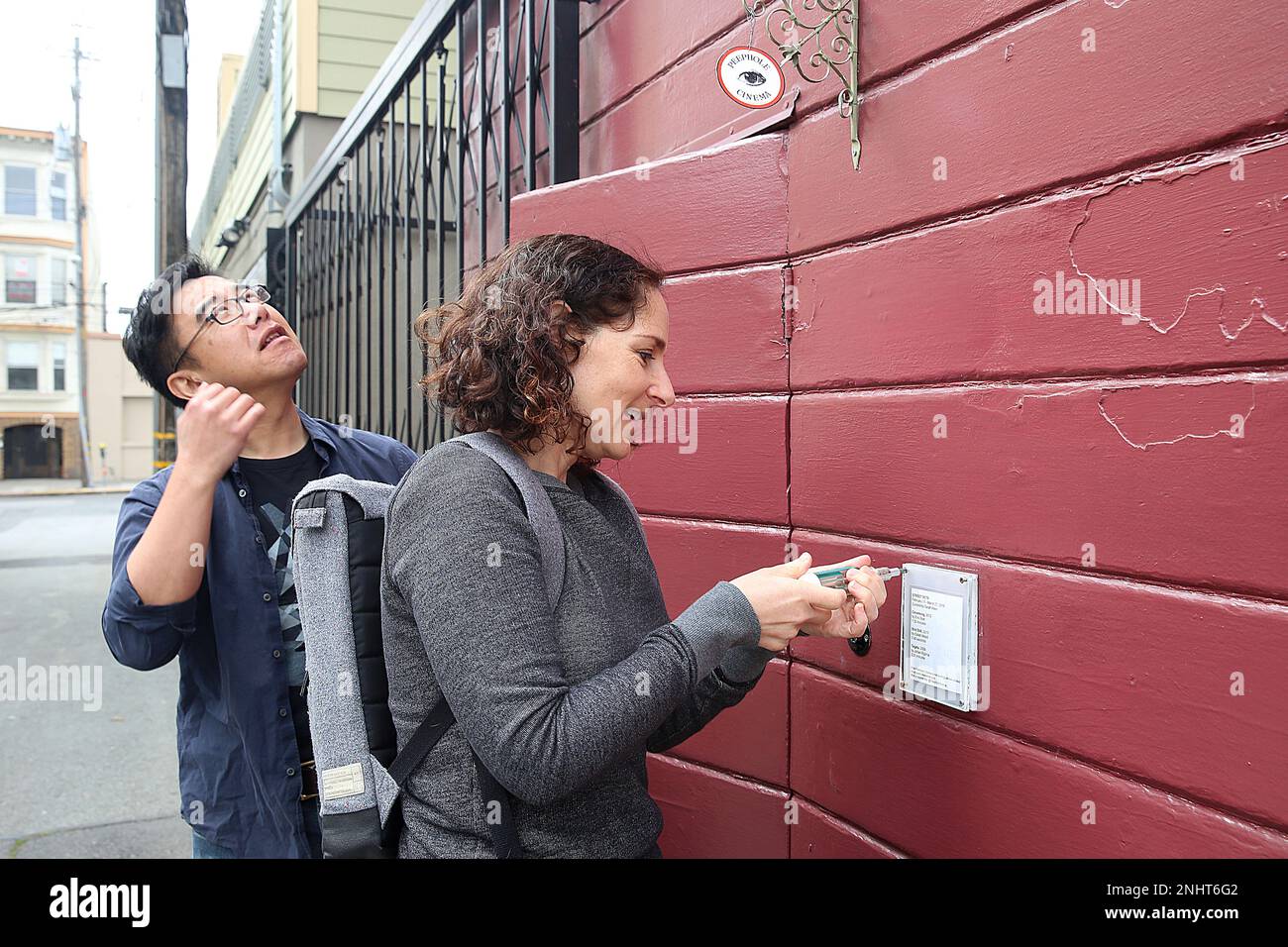 Curator Sarah Klein (right) and David Kwan (left) work on changing the ...