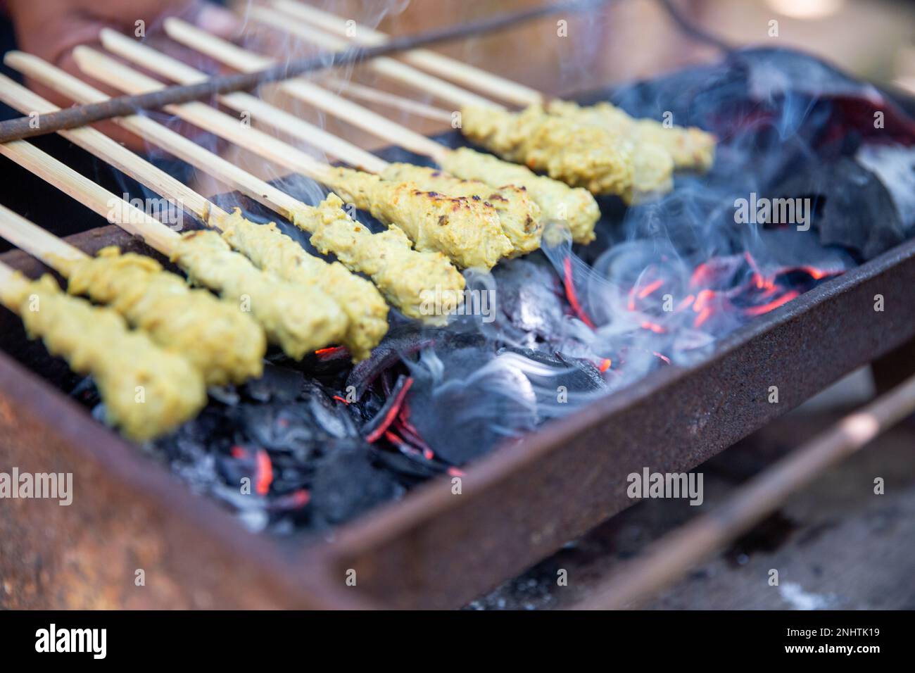 Satay being cooked on the grill Stock Photo - Alamy