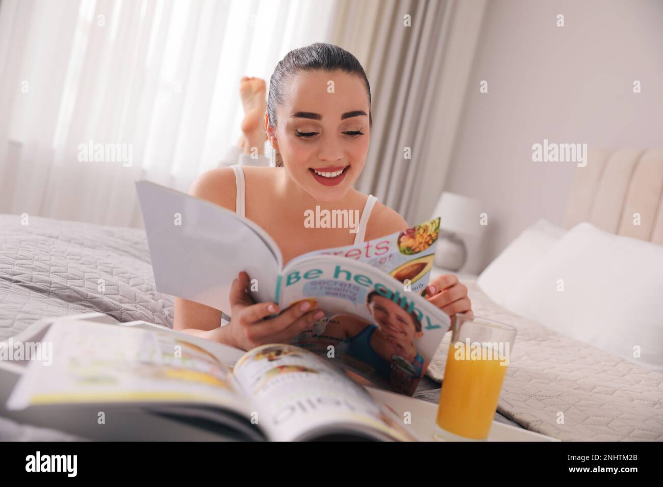 Girl reading magazine on bed hi-res stock photography and images - Alamy