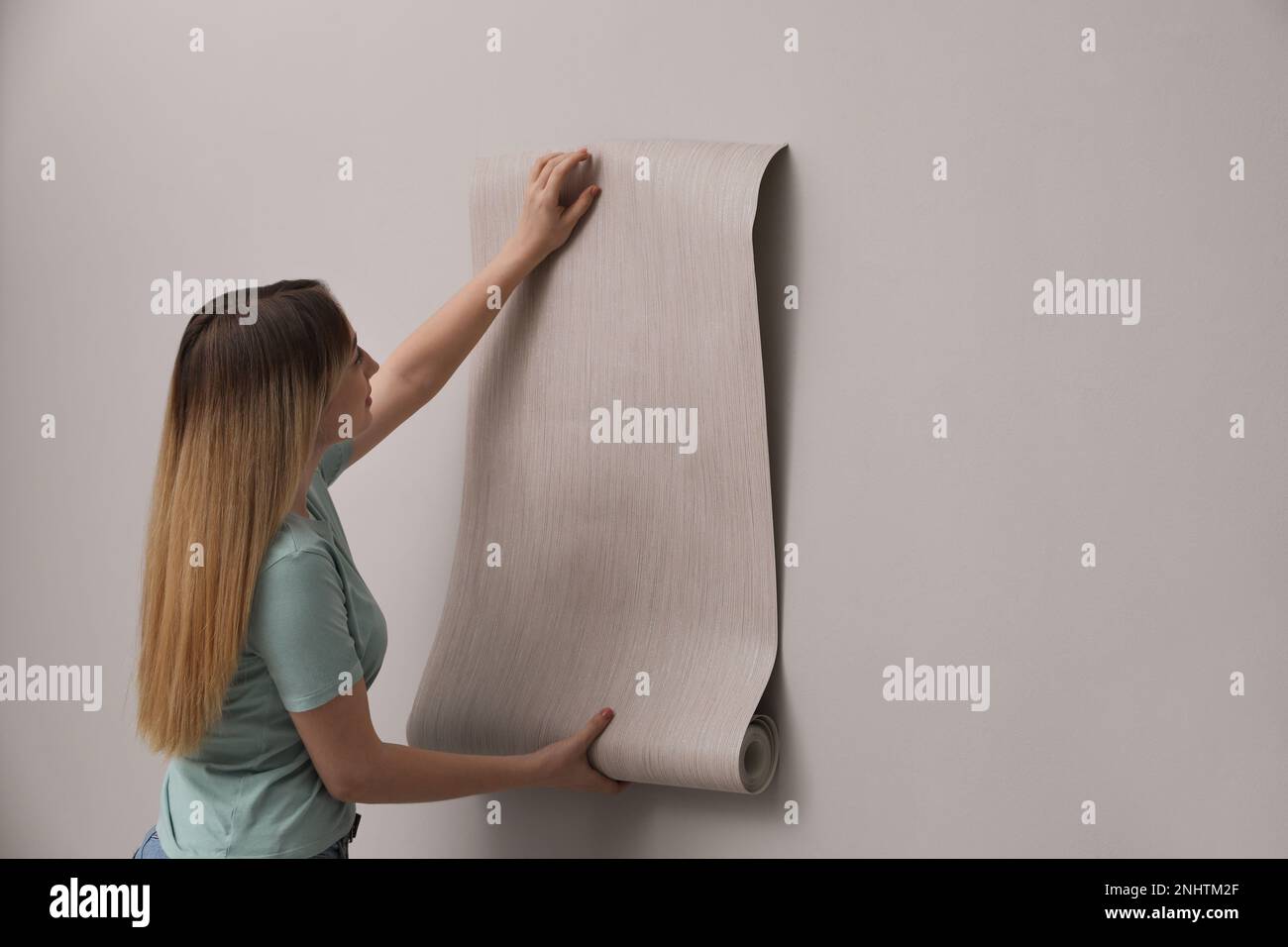 Woman hanging sheet wallpaper indoors hi-res stock photography and ...