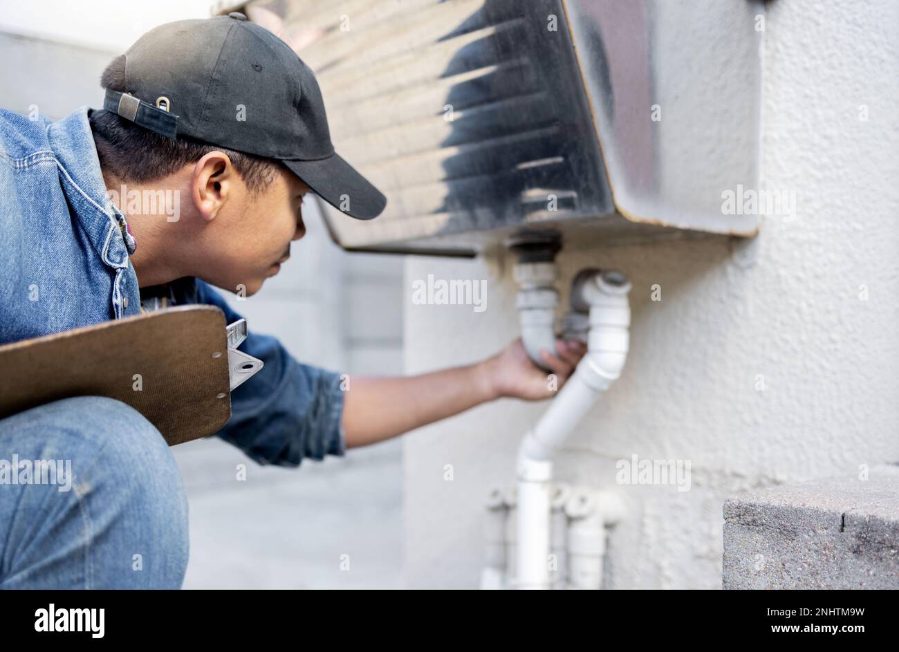 Man, plumber and check faucet pipes for building maintenance ...