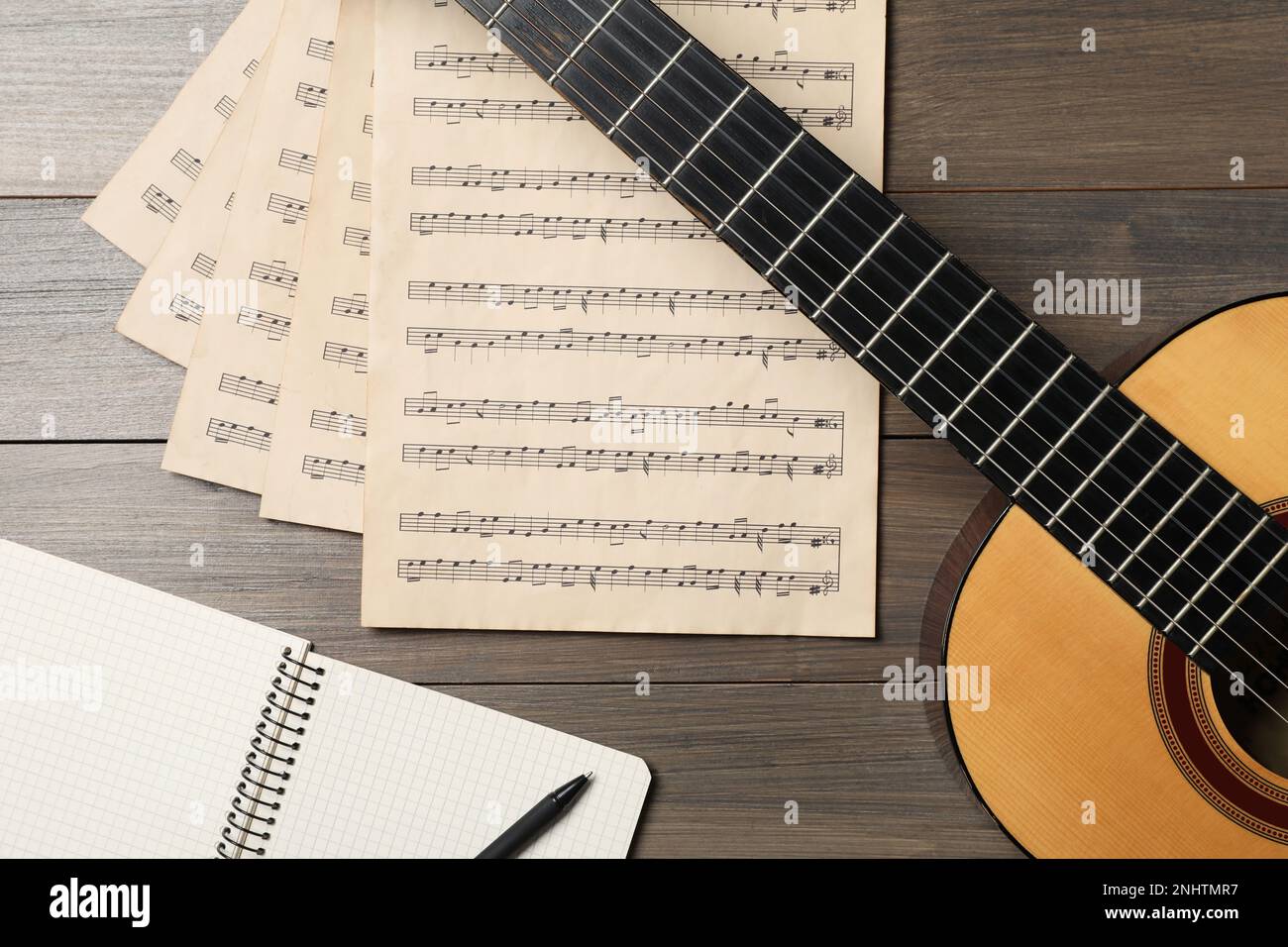 Composition with guitar and music notations on wooden table, flat lay ...