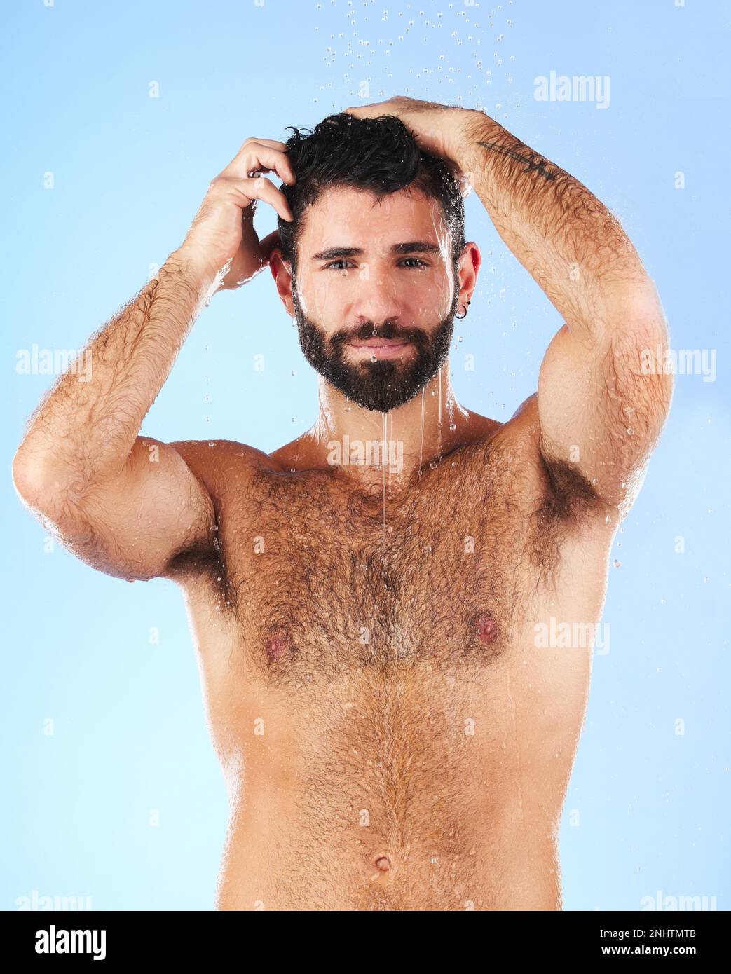 Man, water drop and shower portrait for hygiene, self care and cleaning on blue background in ...
