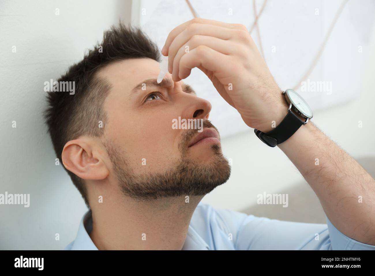 Man using drops for eyes at home Stock Photo - Alamy
