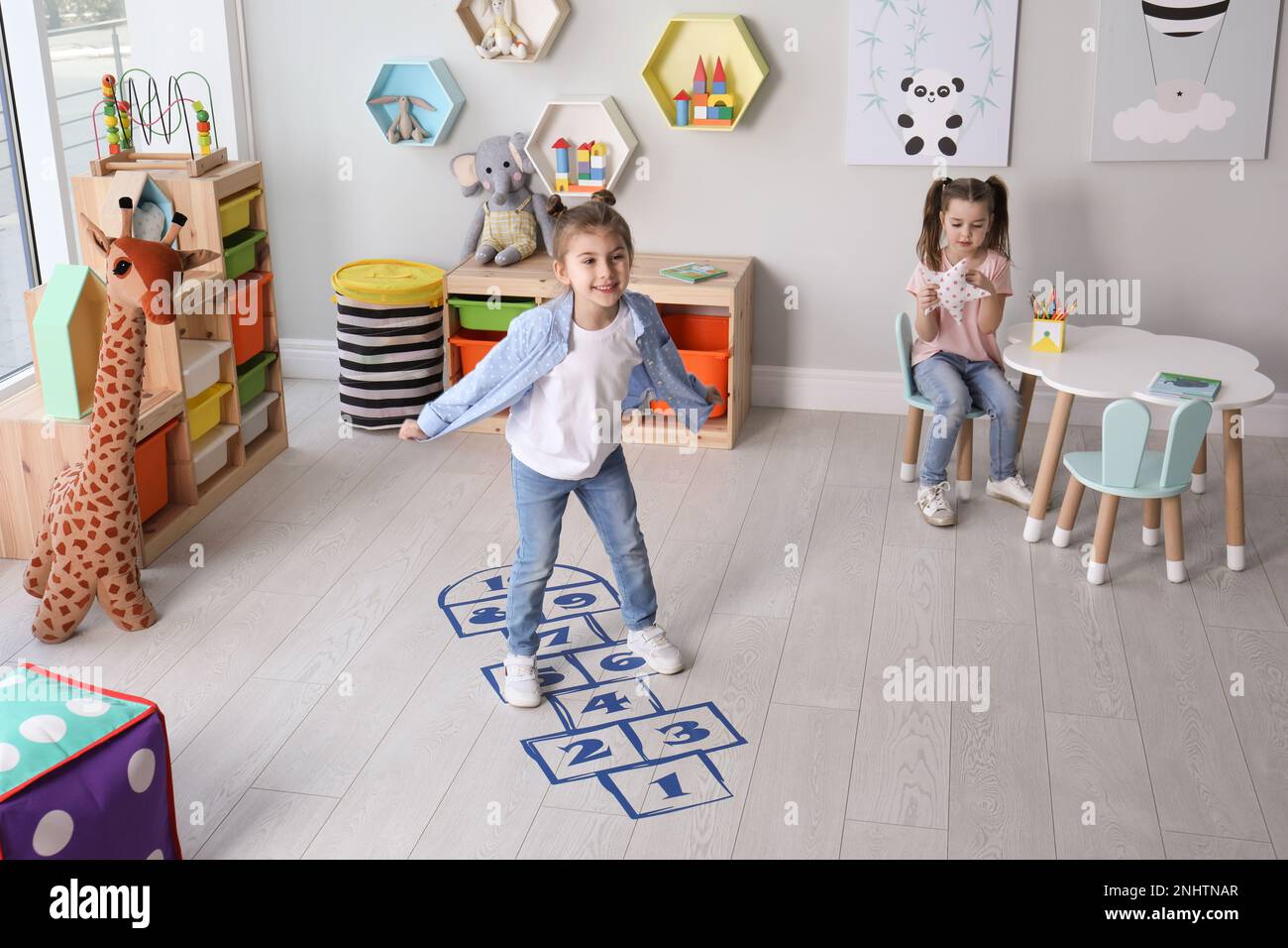 Cute little girls playing hopscotch at home Stock Photo - Alamy