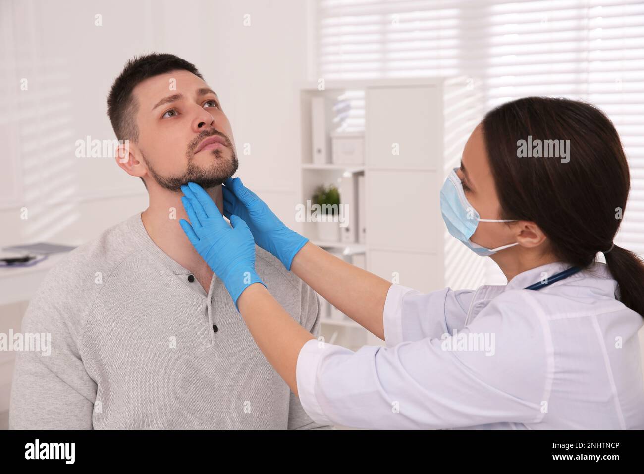 Doctor examining thyroid gland of patient in hospital Stock Photo - Alamy