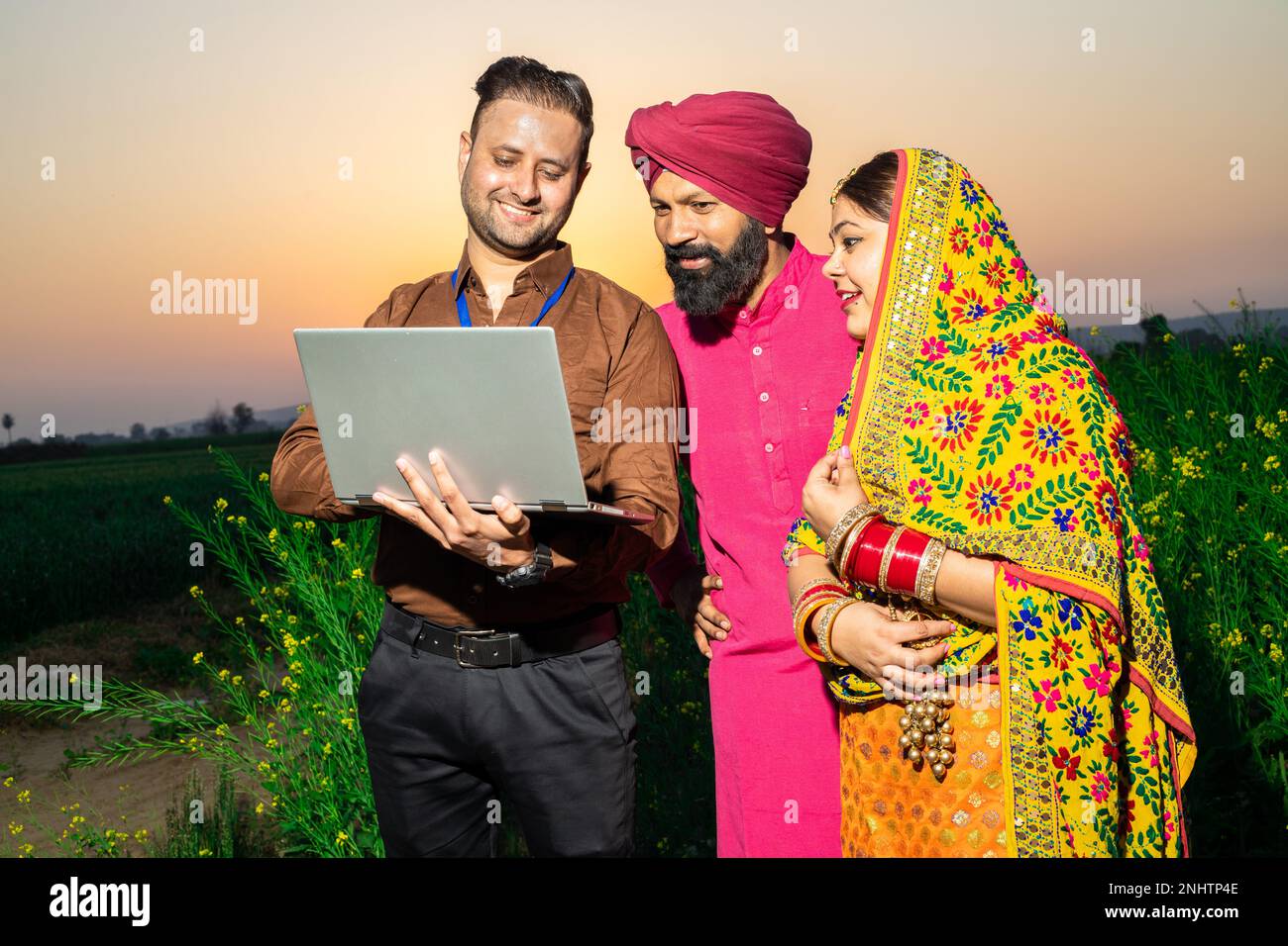 Young indian bank officer or agronomist holding laptop showing and ...