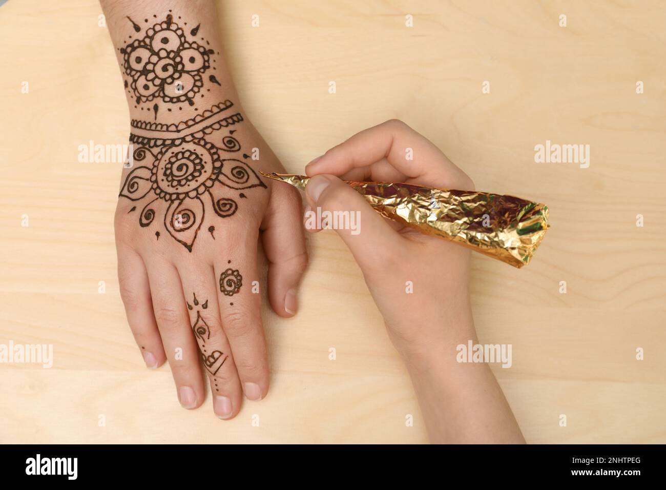 Master making henna tattoo on hand, top view. Traditional mehndi Stock ...